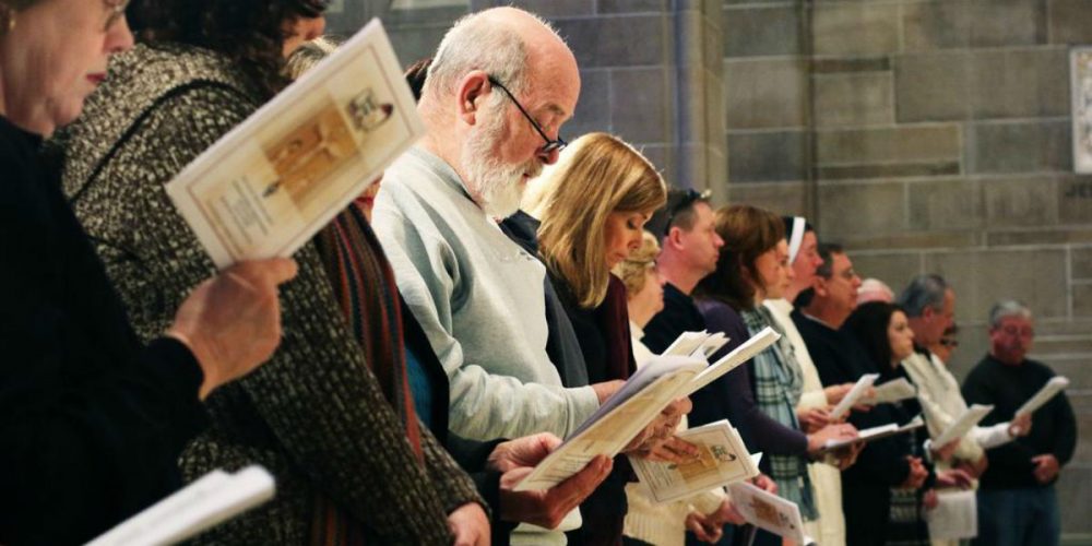 people singing in mass - Crossroads Initiative