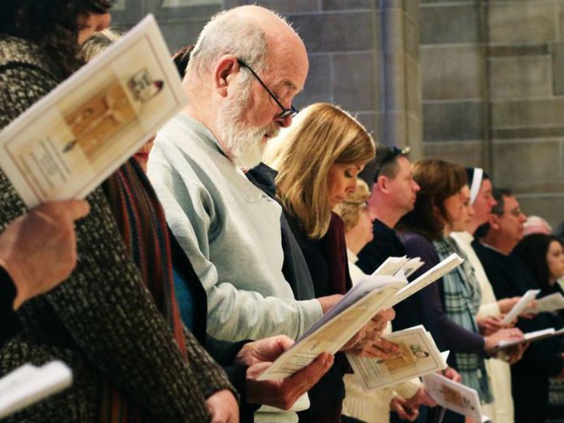 people singing in mass - Crossroads Initiative