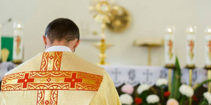 back of priest at mass facing altar - Crossroads Initiative